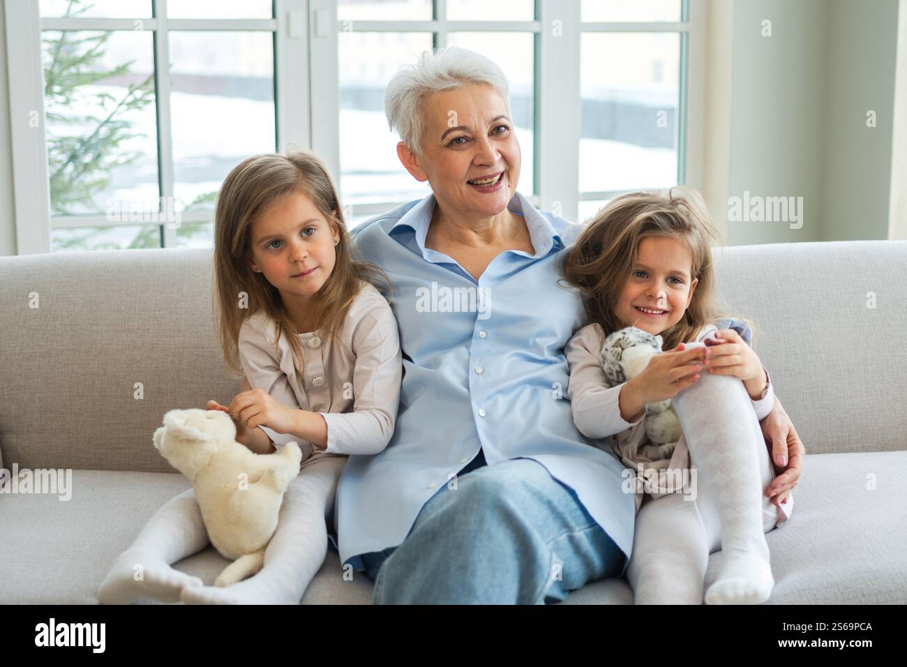 Happy family at home. Two little girls sisters twins grandmother ...