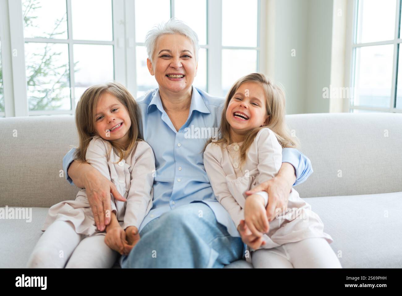 Happy family at home. Two little girls sisters twins grandmother ...