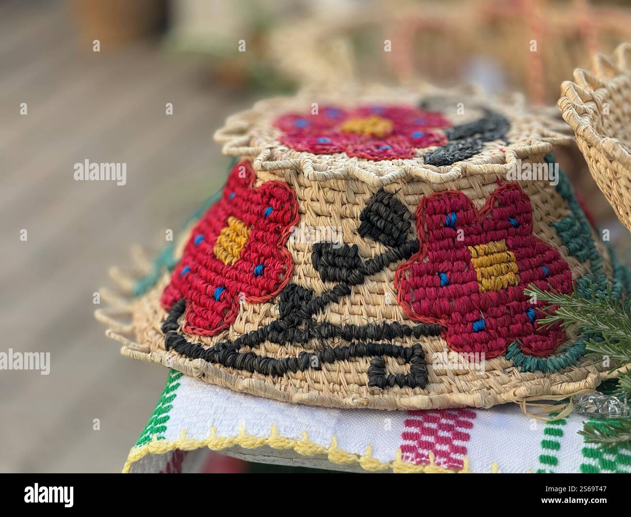 Cretan basket traditionally woven with patterns of red flowers with ...