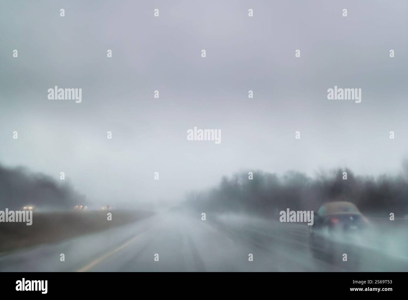 Cars driving in bad weather conditions with fog and heavy rain on ...