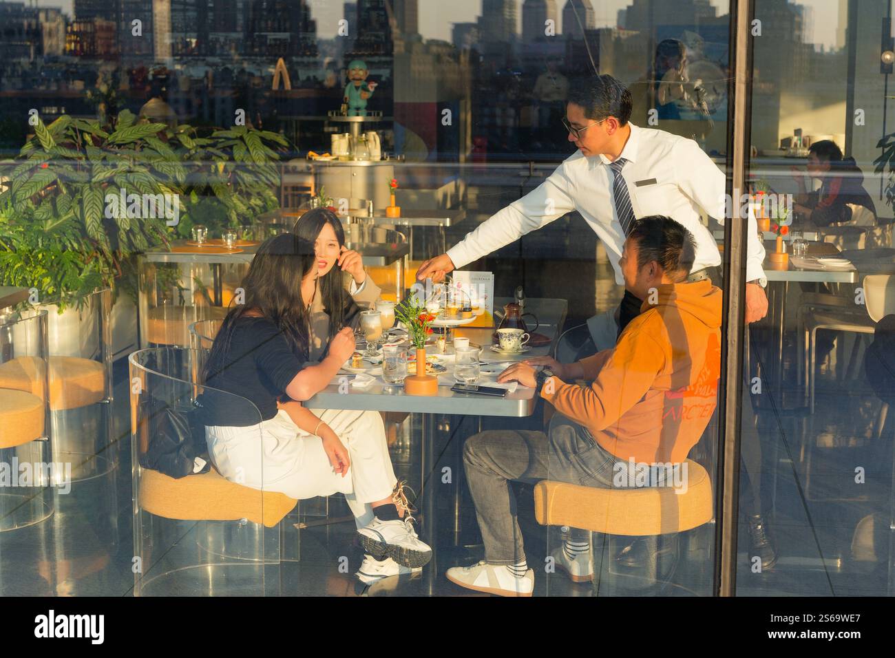 A vibrant dining scene showing a group of three people enjoying tea and ...