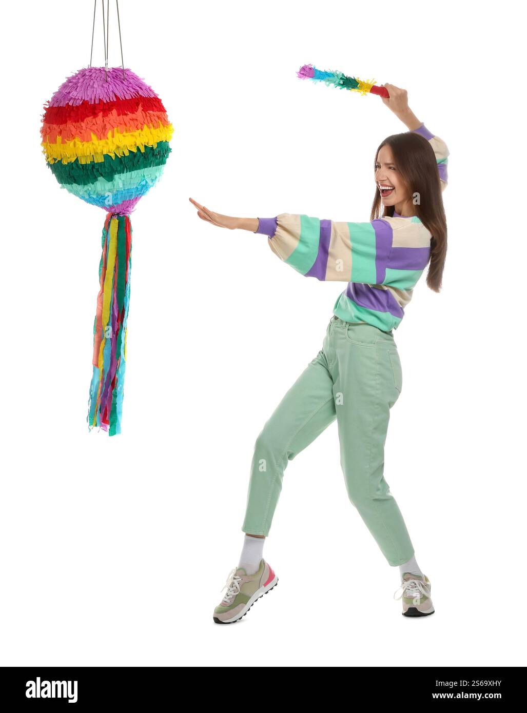 Happy woman breaking colorful pinata with stick on white background ...