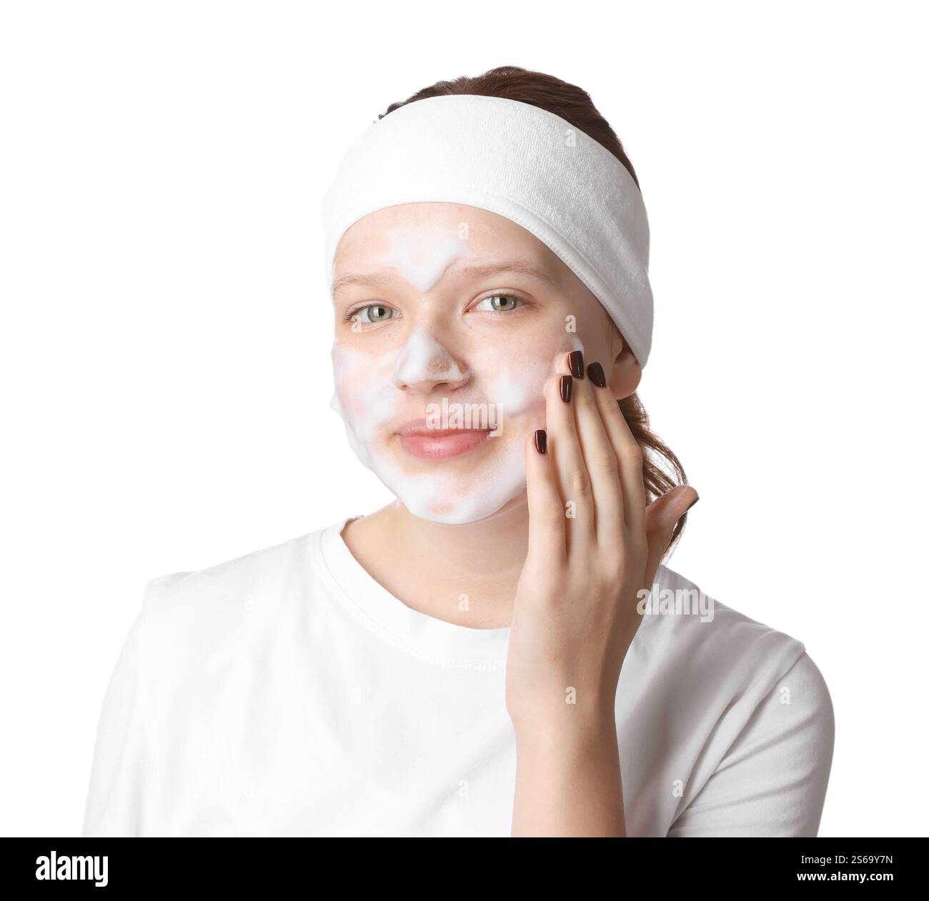 Teenage girl washing her face with cleanser on white background ...