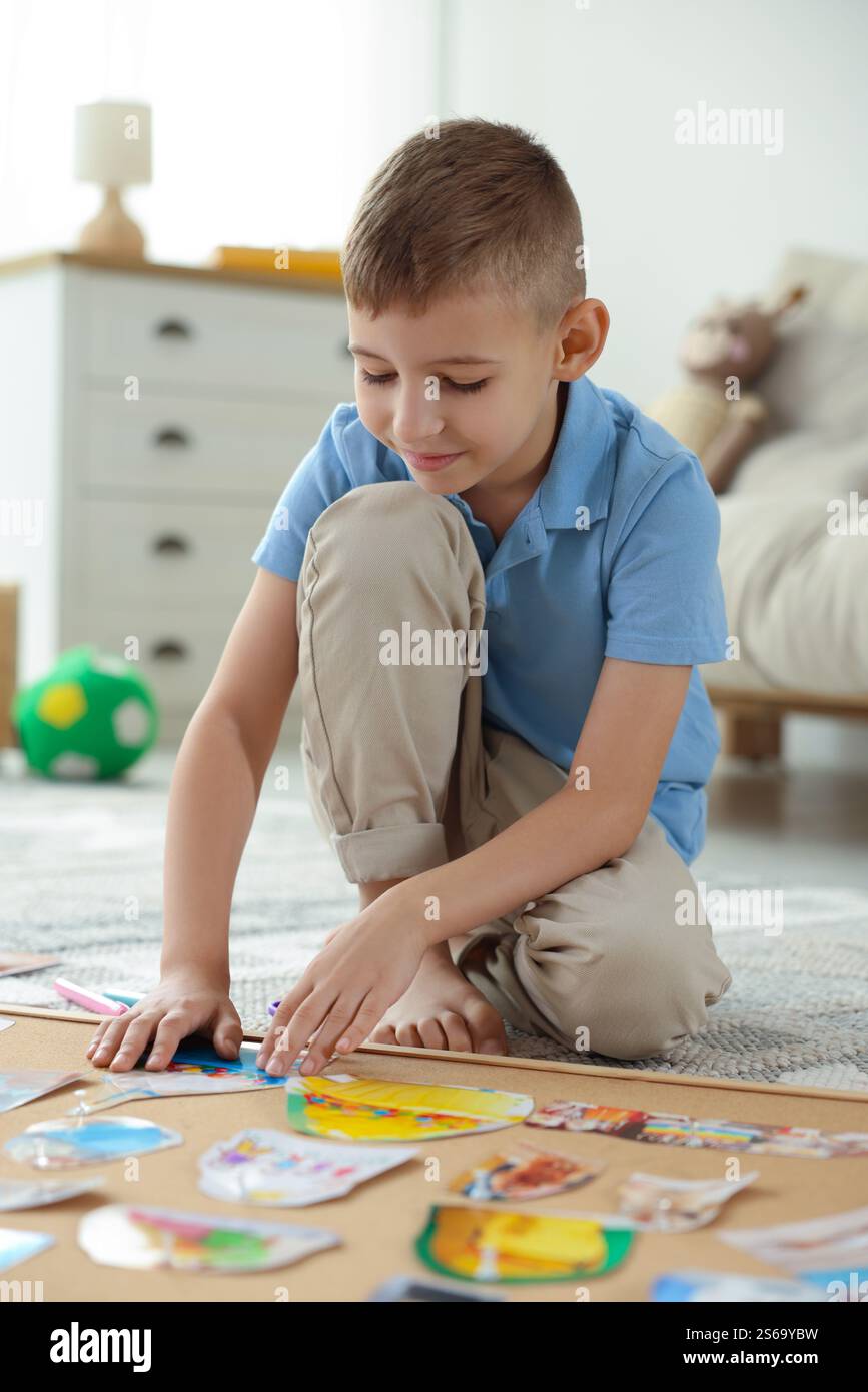 Little boy creating vision board with different pictures and other ...