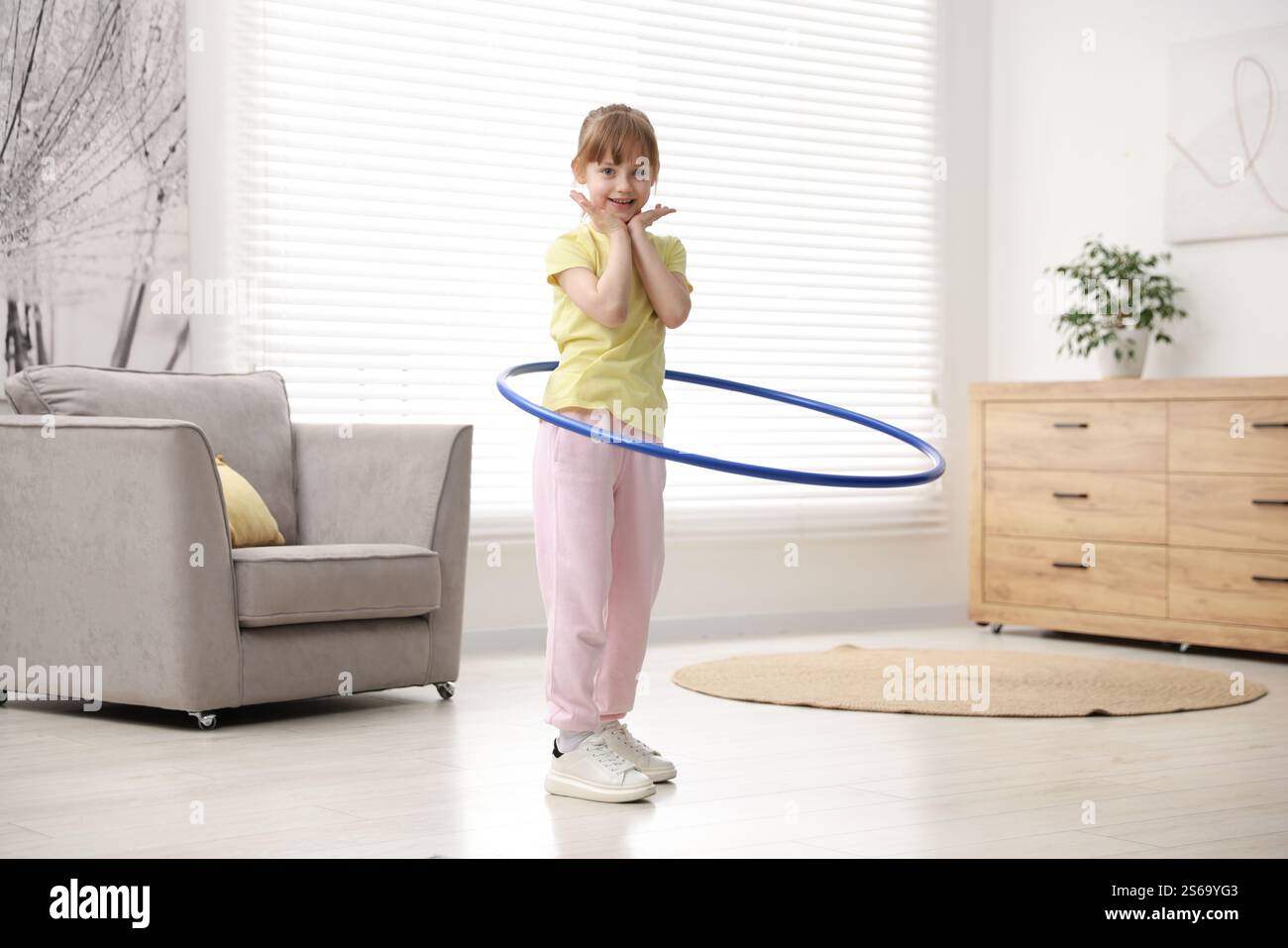 Cute little girl exercising with hula hoop at home Stock Photo - Alamy