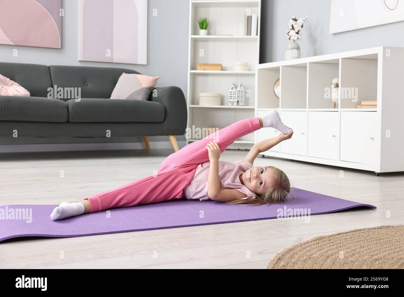Little girl exercising on fitness mat at home. Sport activity Stock ...