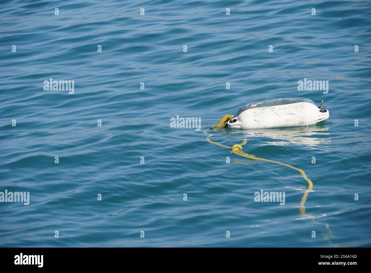 Small white mooring buoy with yellow rope for private yachts and motor ...