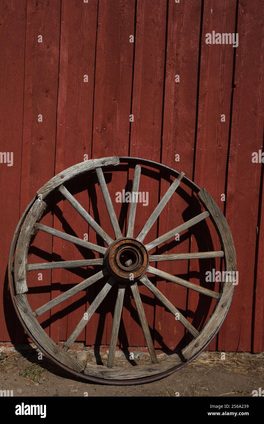 wagon wheel resting against barn wall Stock Photo - Alamy