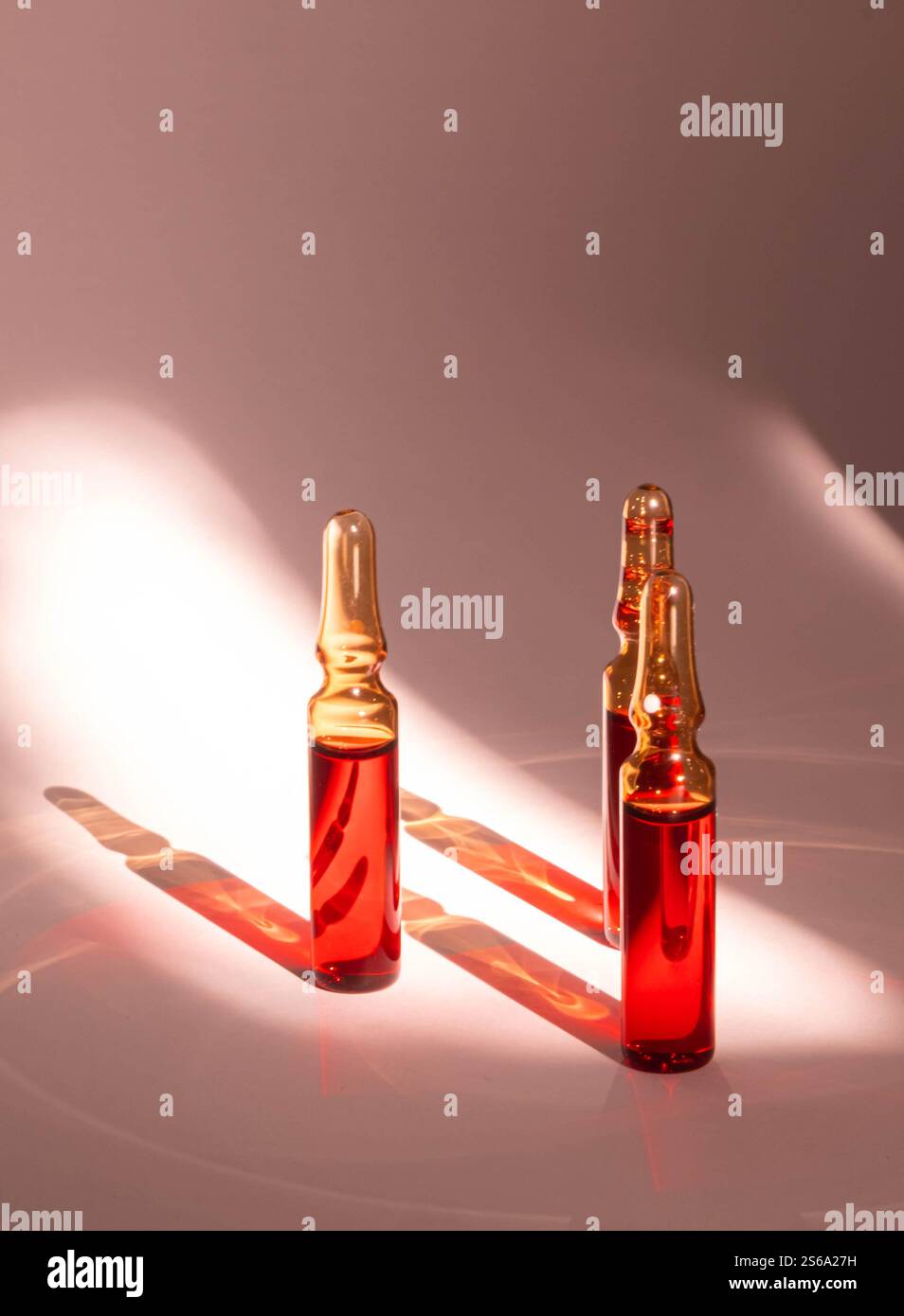 injections of B vitamins. Ampoules with red liquid on a peachy ...