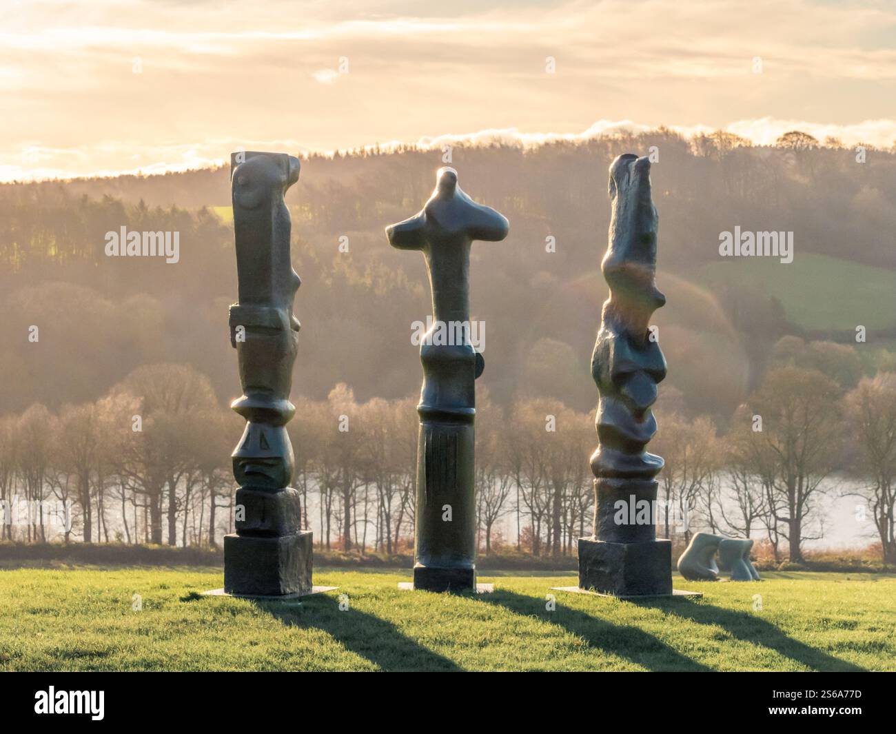 Hazy backlit Henry Moore's Upright Motives No. 1 (Glenkiln Cross): No 2; No 7 casting long ...
