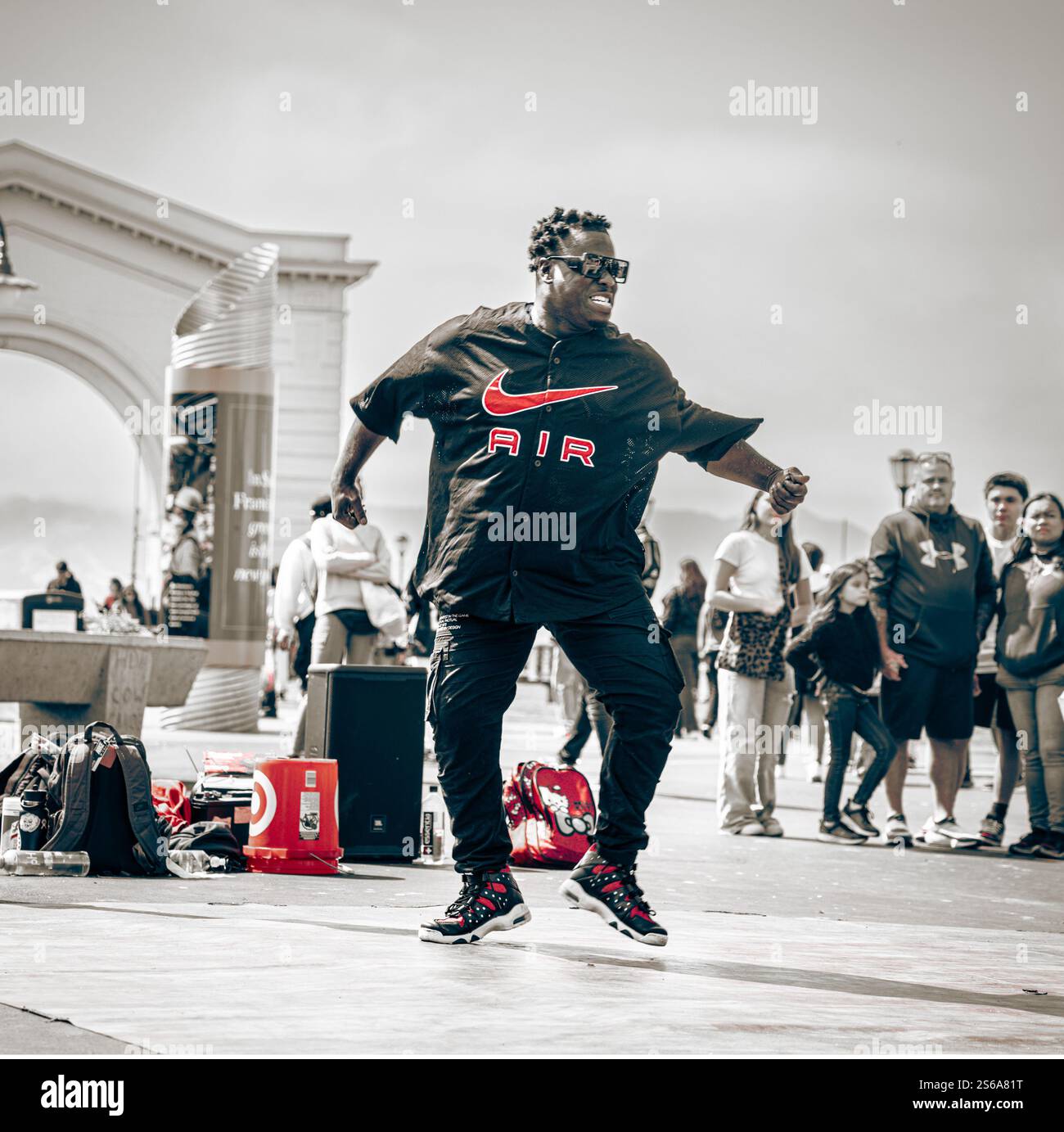 A street performer dancing energetically in a public space, sporting a ...