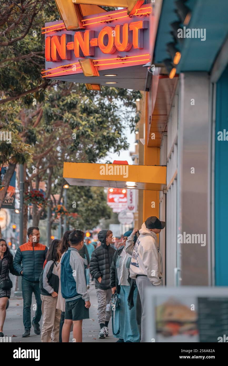 People waiting in line outside an In-N-Out restaurant with its iconic ...