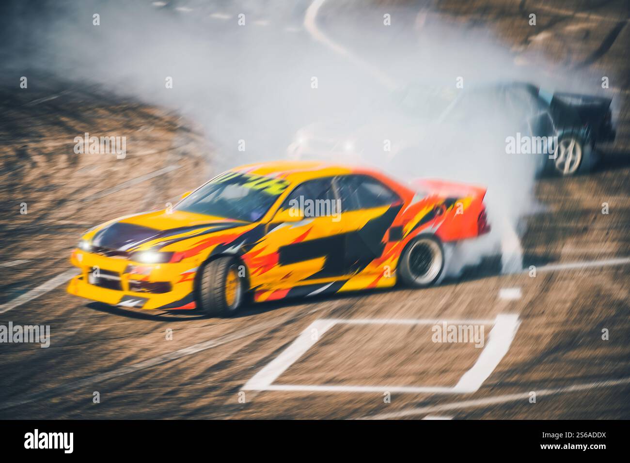 Blurred racing drift car with lots of smoke from burnt rubber wheels ...