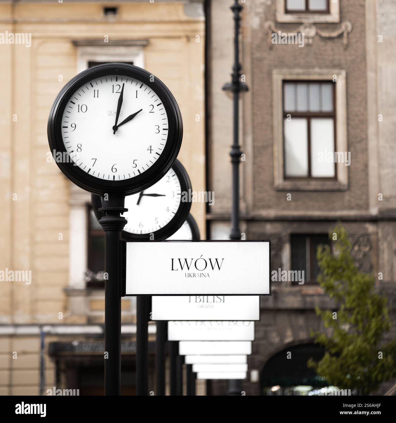 A row of stylish black street clocks displaying different time zones, set against a backdrop of ...
