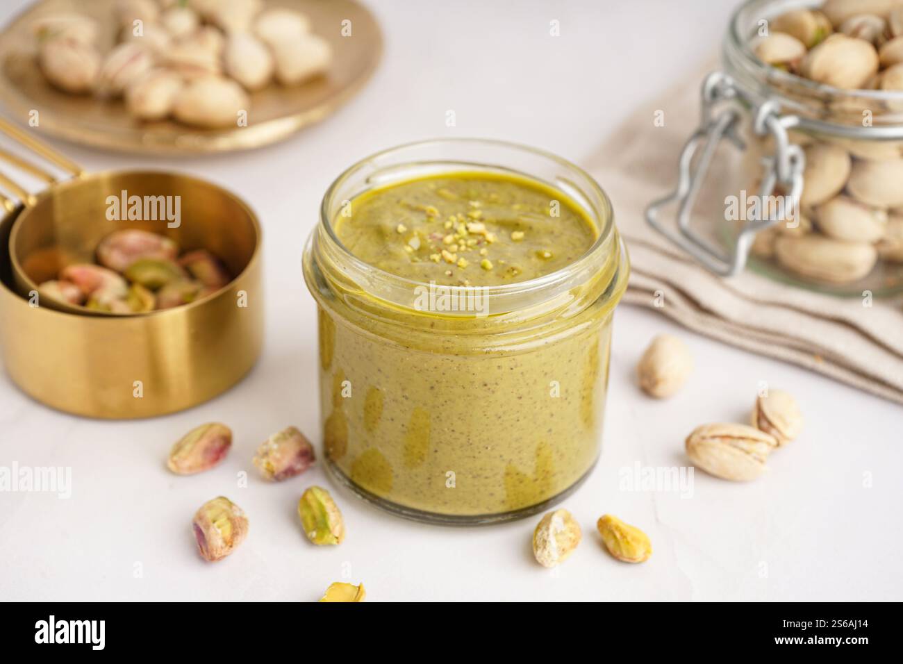 Jar of pistachio paste and measuring cups on white background Stock ...