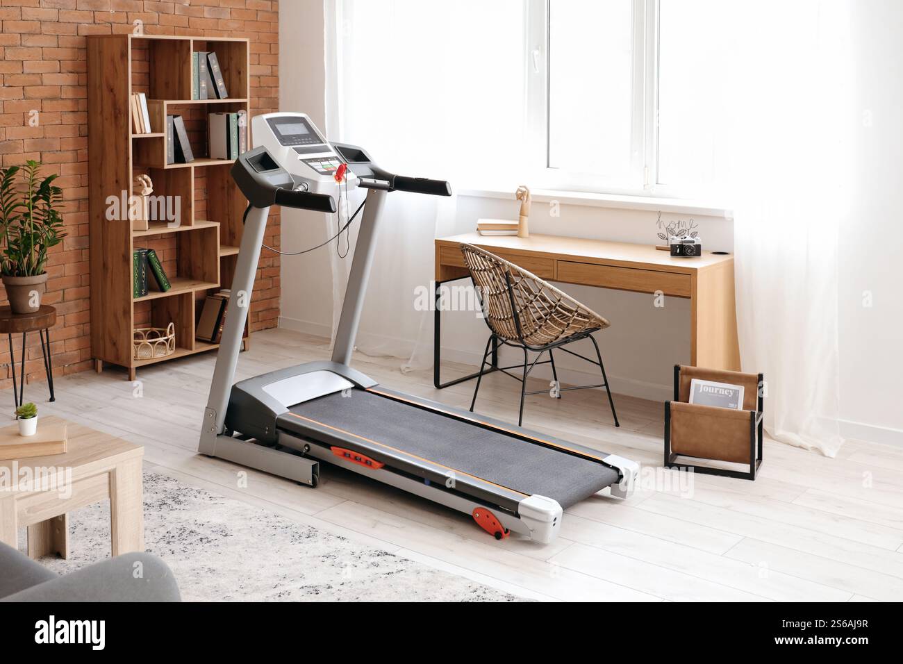 Interior of living room with treadmill, table and shelf unit Stock ...