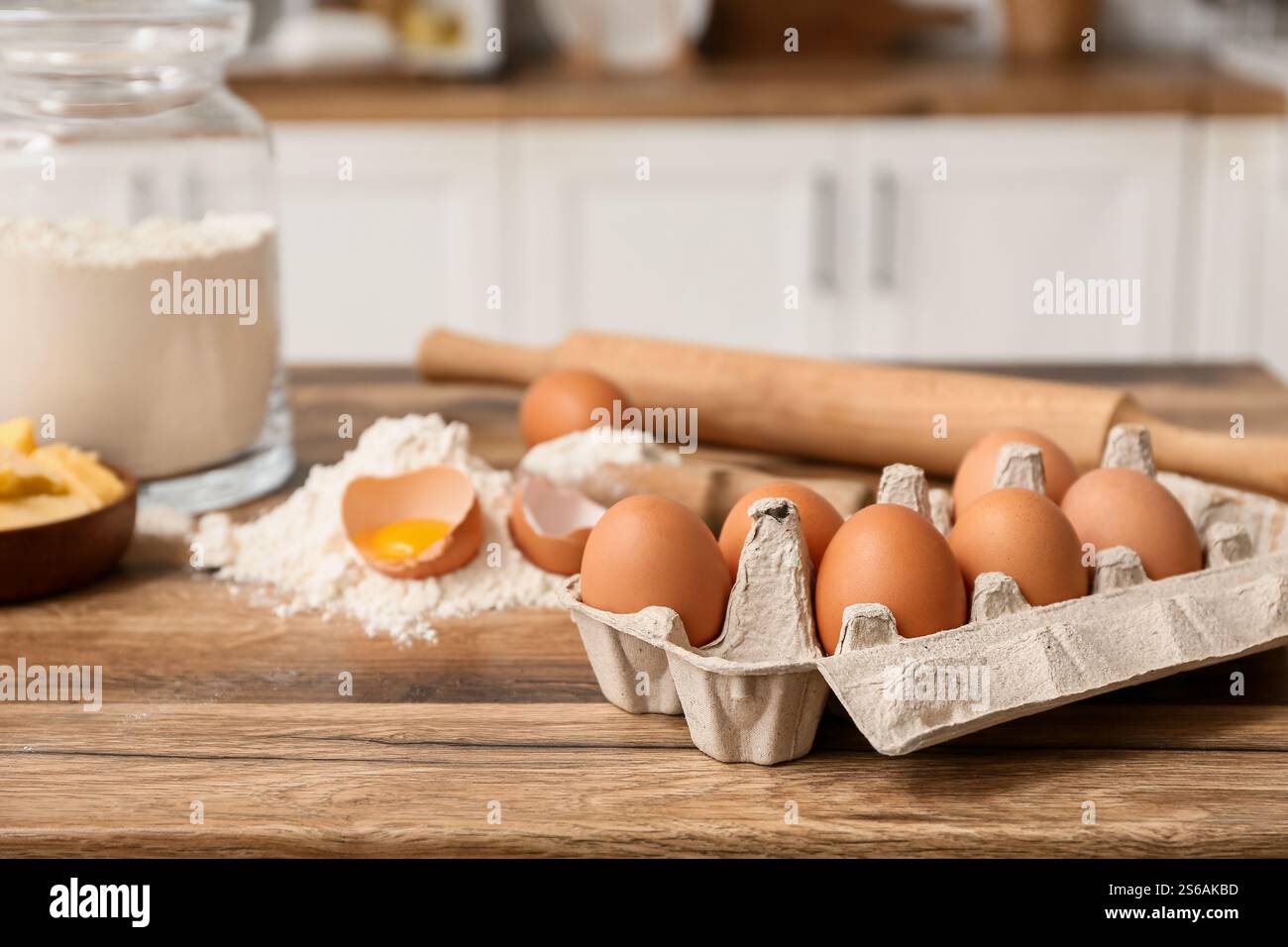 Box with eggs and heap of flour for preparing dough on kitchen counter ...