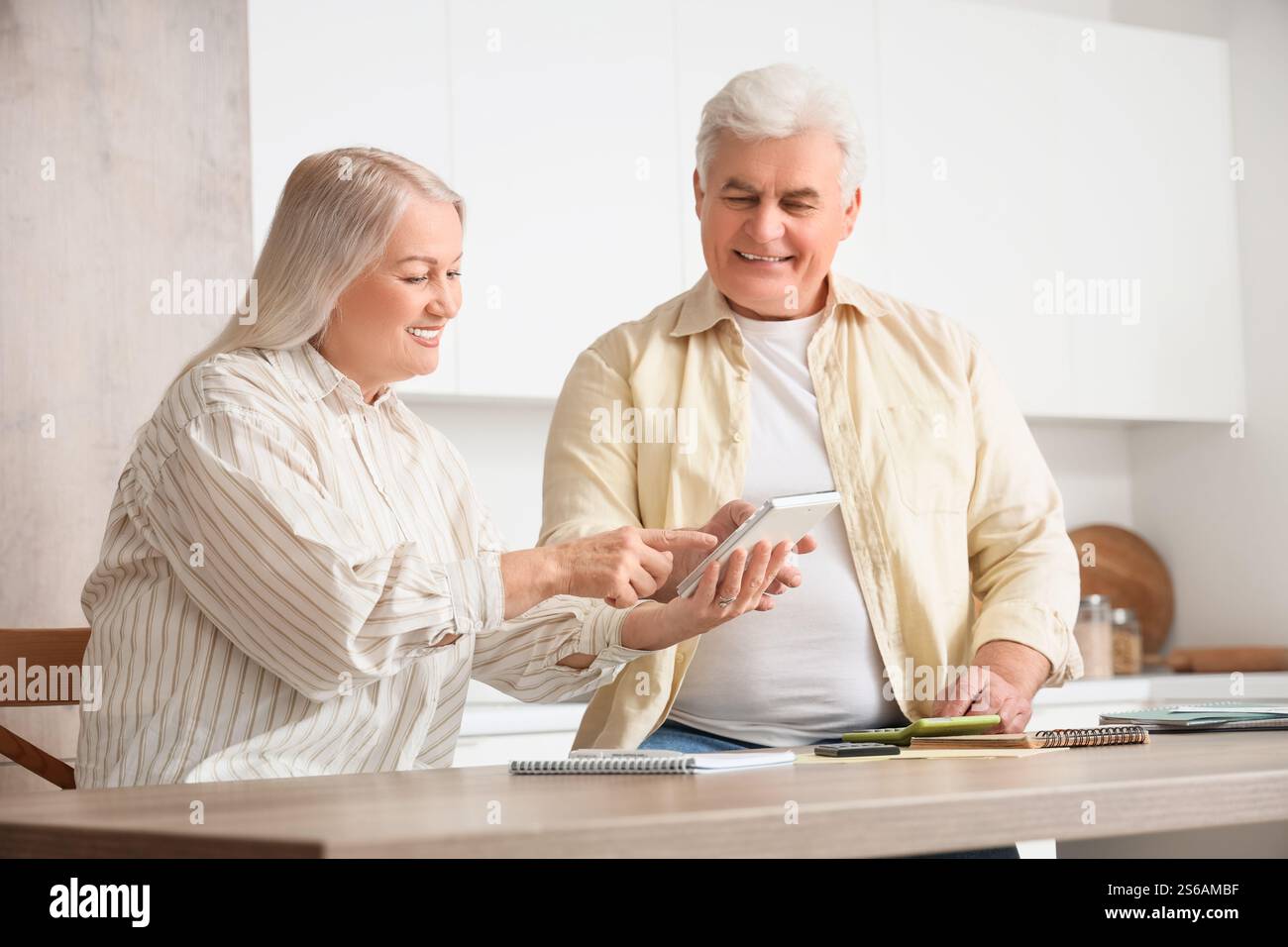 Senior couple calculating utility bills in kitchen Stock Photo - Alamy