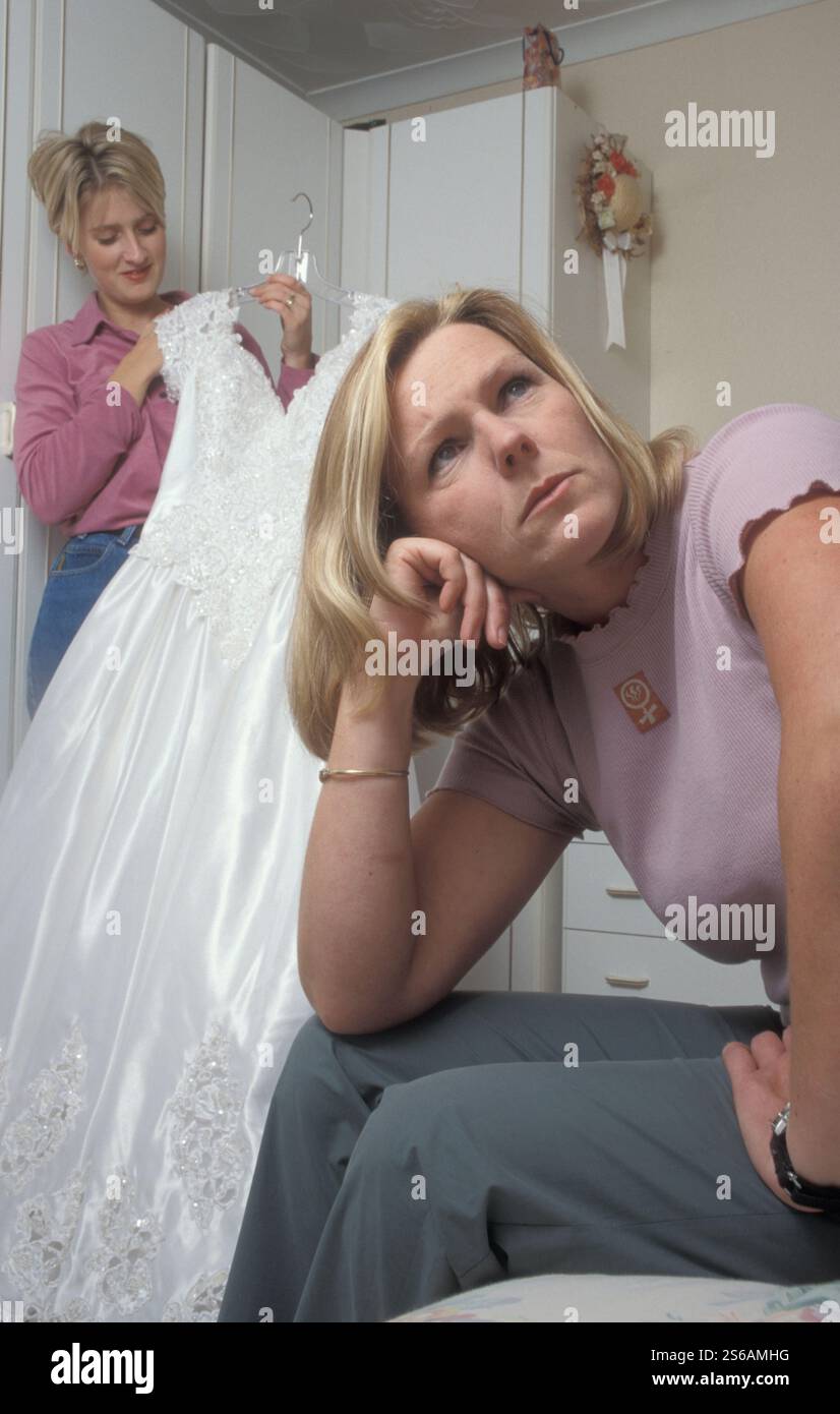a woman looks envious as her friend takes our her wedding dress Stock ...