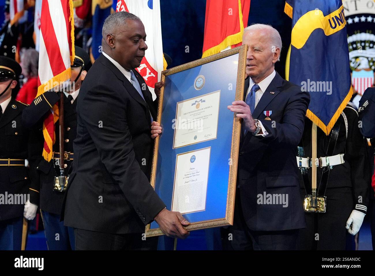 Defense Secretary Lloyd Austin, left, presents a plaque to President ...