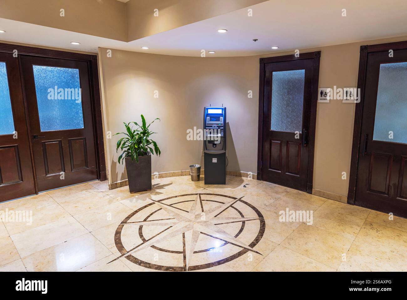ATM machine in hotel lobby near restroom entrances with decorative ...