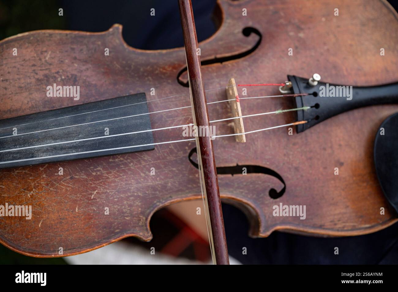A detailed view of a vintage violin showing its worn wooden surface ...