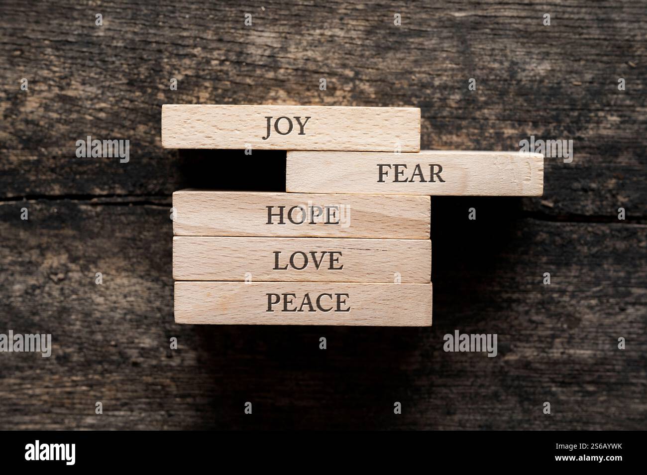 Wooden blocks labeled Joy, Fear, Hope, Love, and Peace stacked together ...