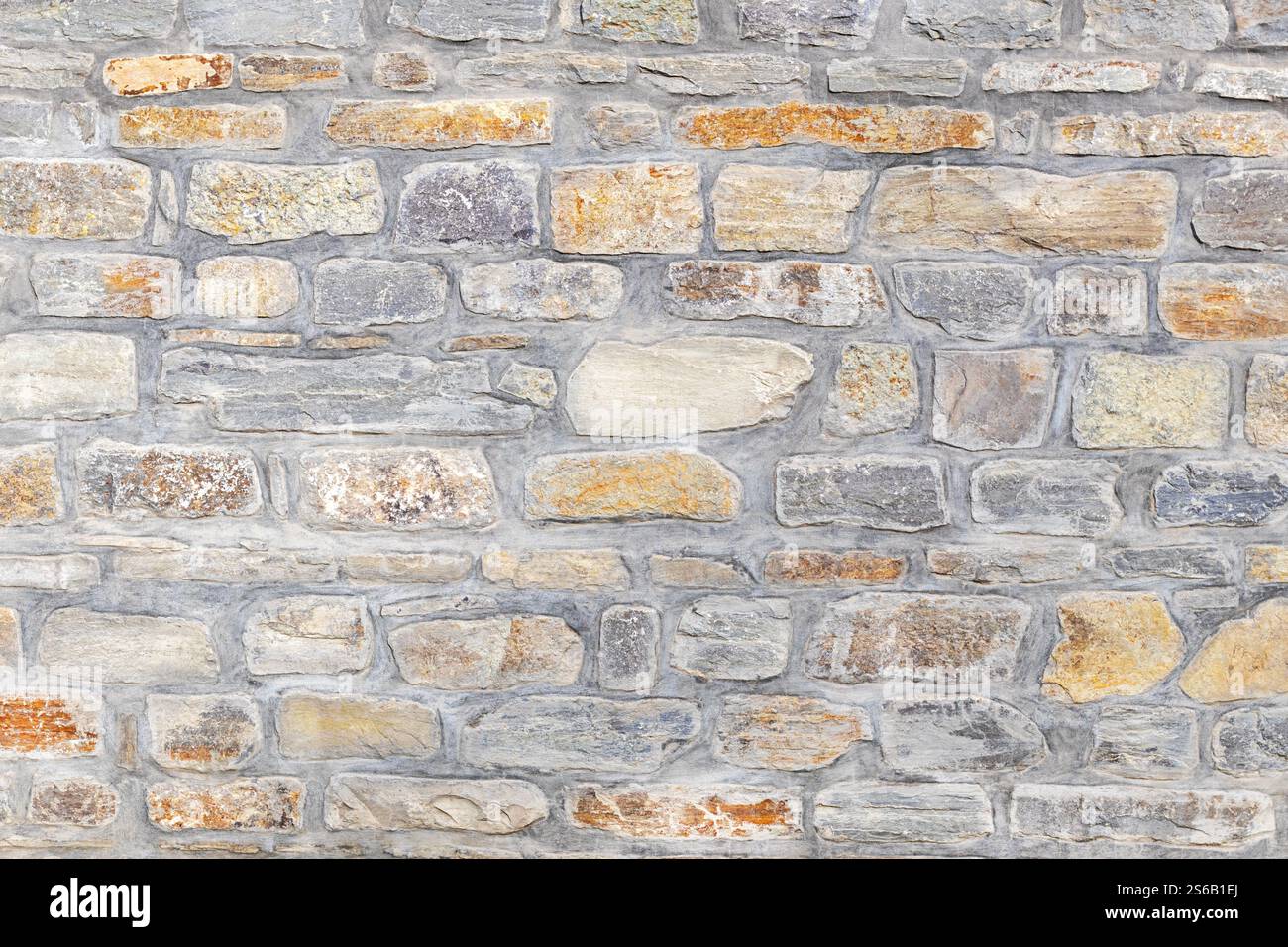 Natural stone wall with various shapes and colors creating a rustic ...