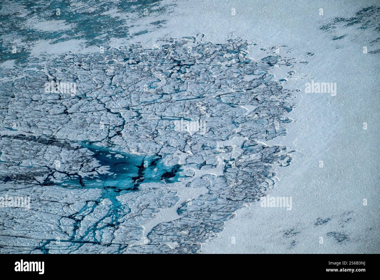 Glacier surface reveals intricate patterns and deep blue veins carved ...