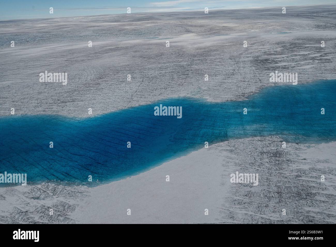 Bright blue pool forms on glacier surface during summer melt season ...