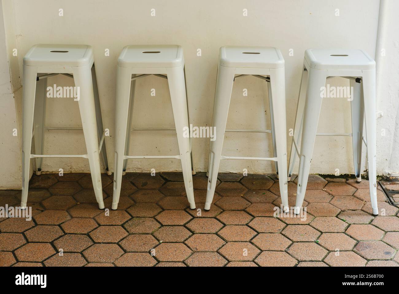 Four white metal stools Stock Photo - Alamy