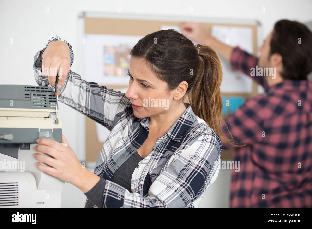 middle aged woman doing printer maintenance Stock Photo - Alamy