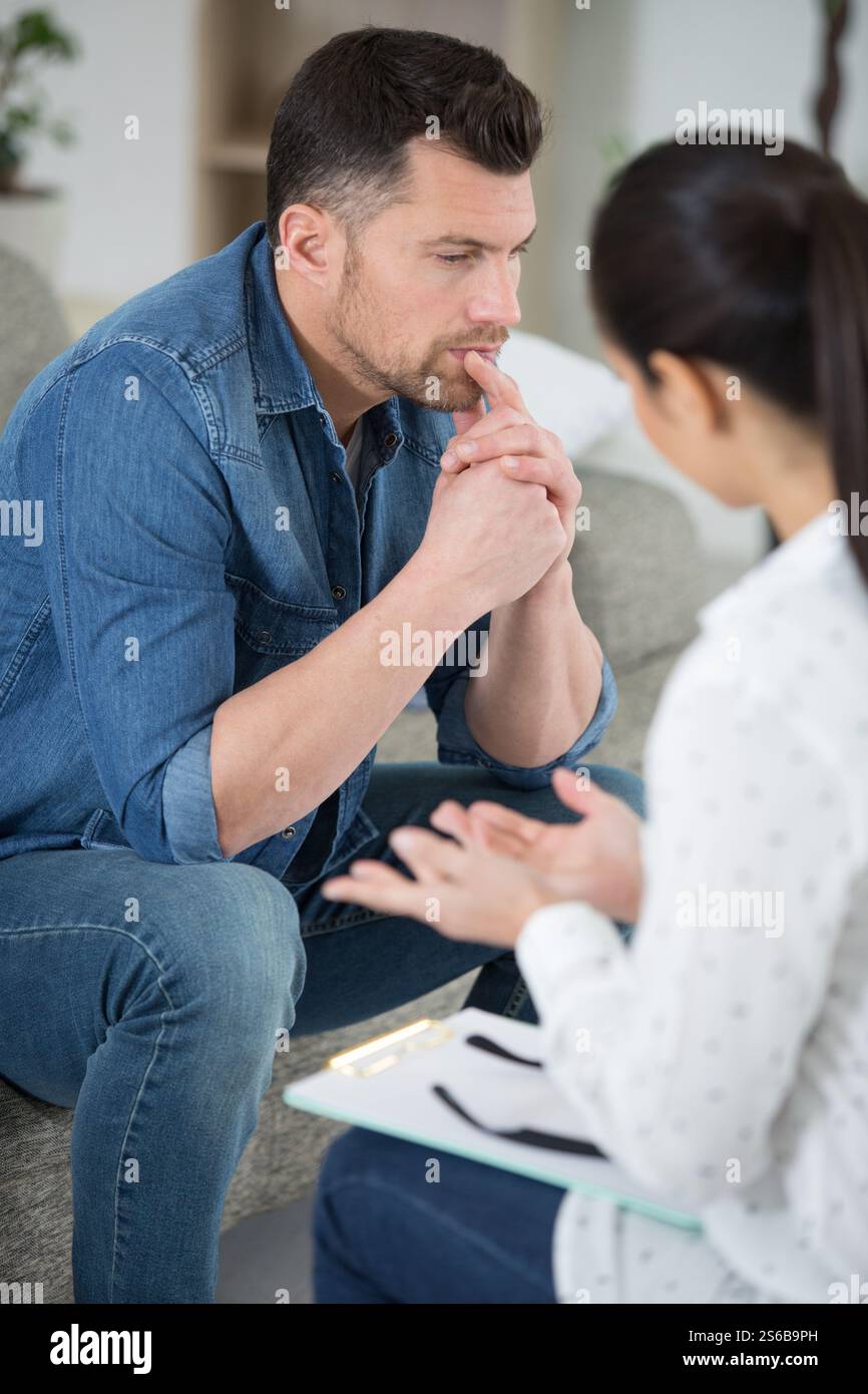 counselor taking notes while analyzing young man Stock Photo - Alamy