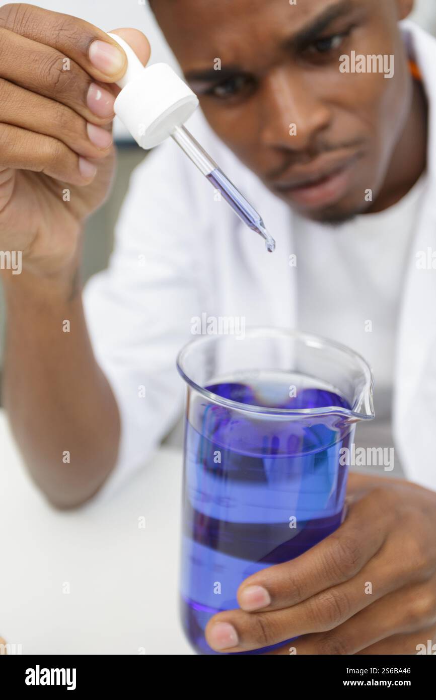young scientist with violet solution in pipette dropper Stock Photo - Alamy