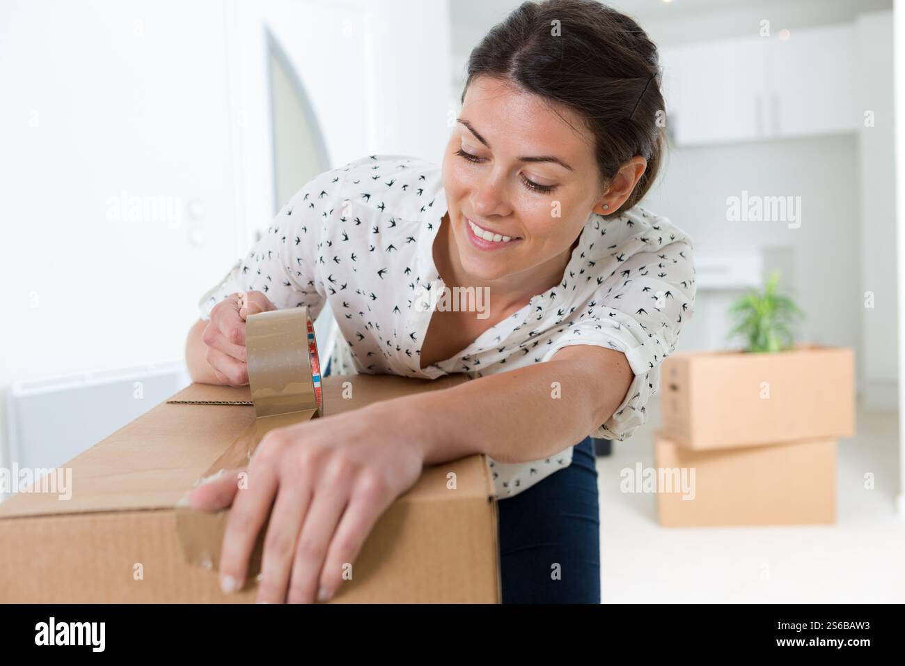 portrait of a woman taping her box Stock Photo - Alamy