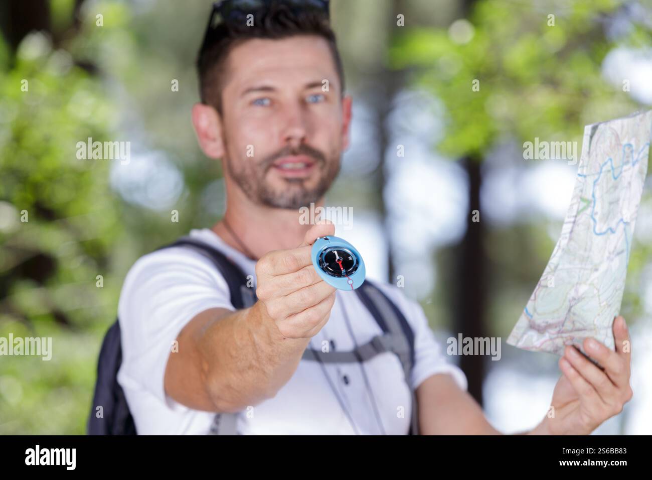 man in the countryside with map showing compass Stock Photo - Alamy