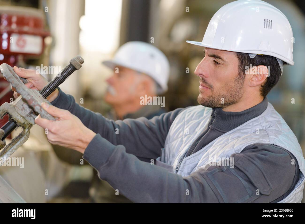industrial worker turning wheel on threaded bar Stock Photo - Alamy