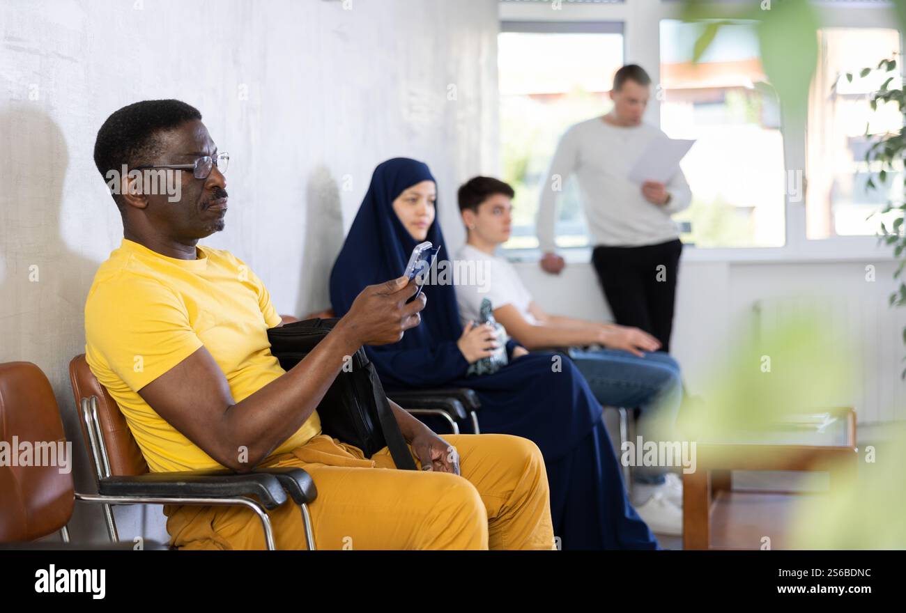 Adult african man waiting in line with phone in his hand Stock Photo ...