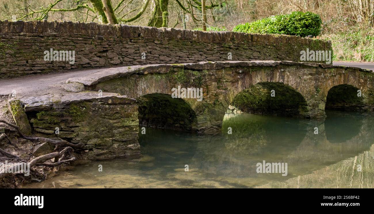 ByBrook River and stone bridge at Castle Combe village in the Cotswolds ...