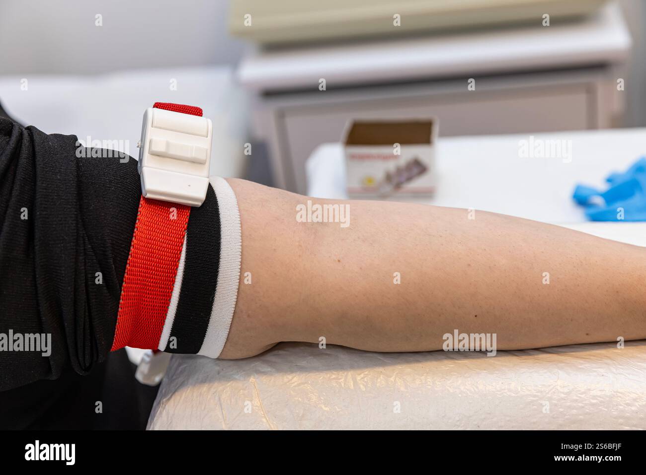 Doctor or nurse taking a blood sample from arm vein with a vacutainer ...
