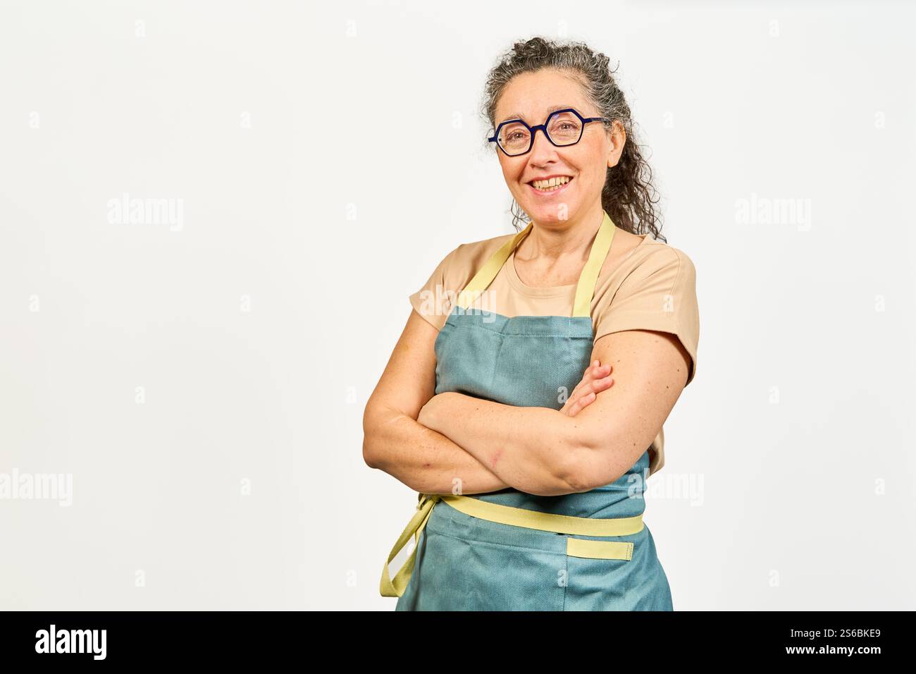 Portrait of confident mature female chef smiling with crossed arms ...