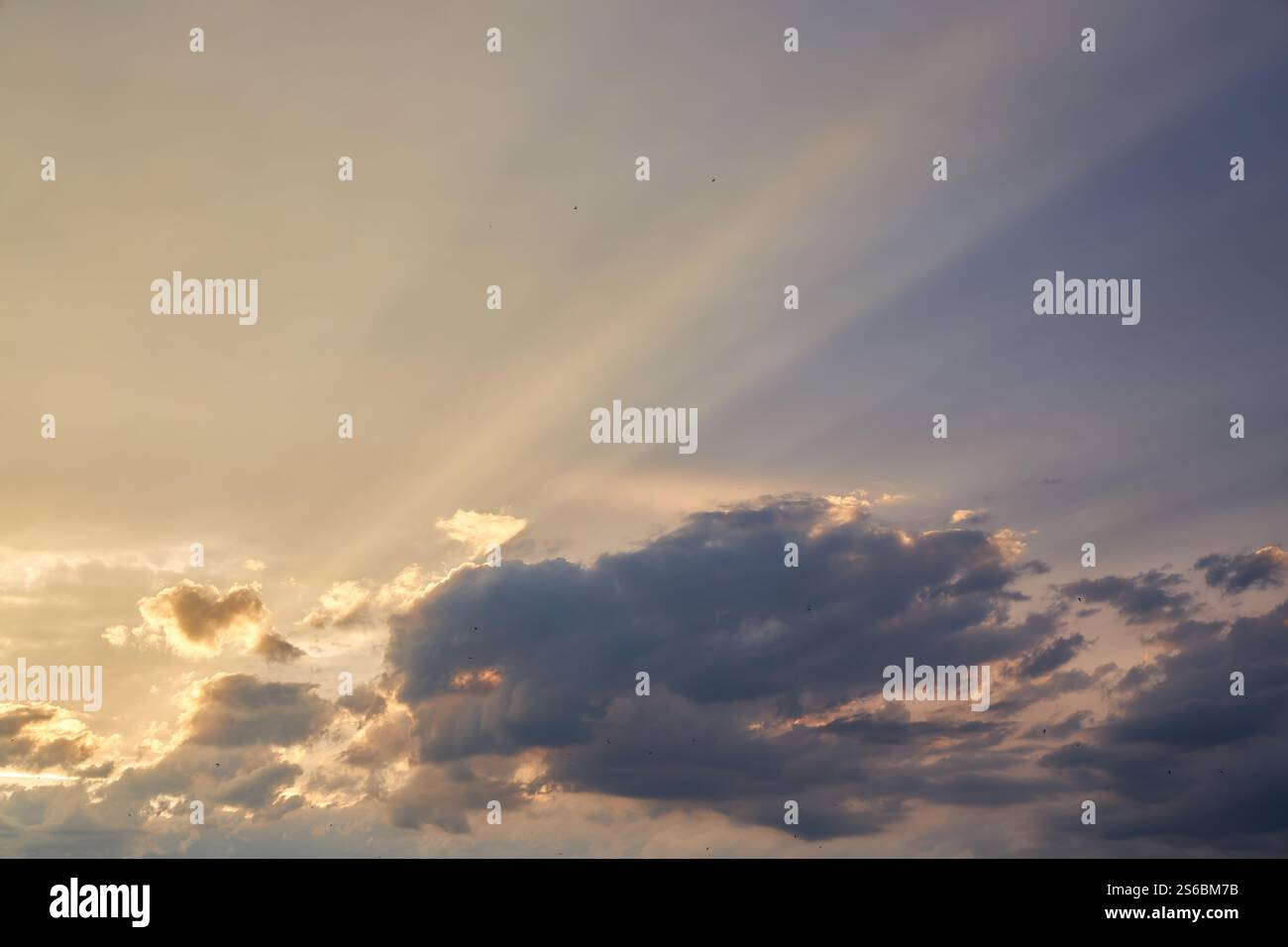 Dramatic sky with sun rays breaking through clouds during dusk, casting ...