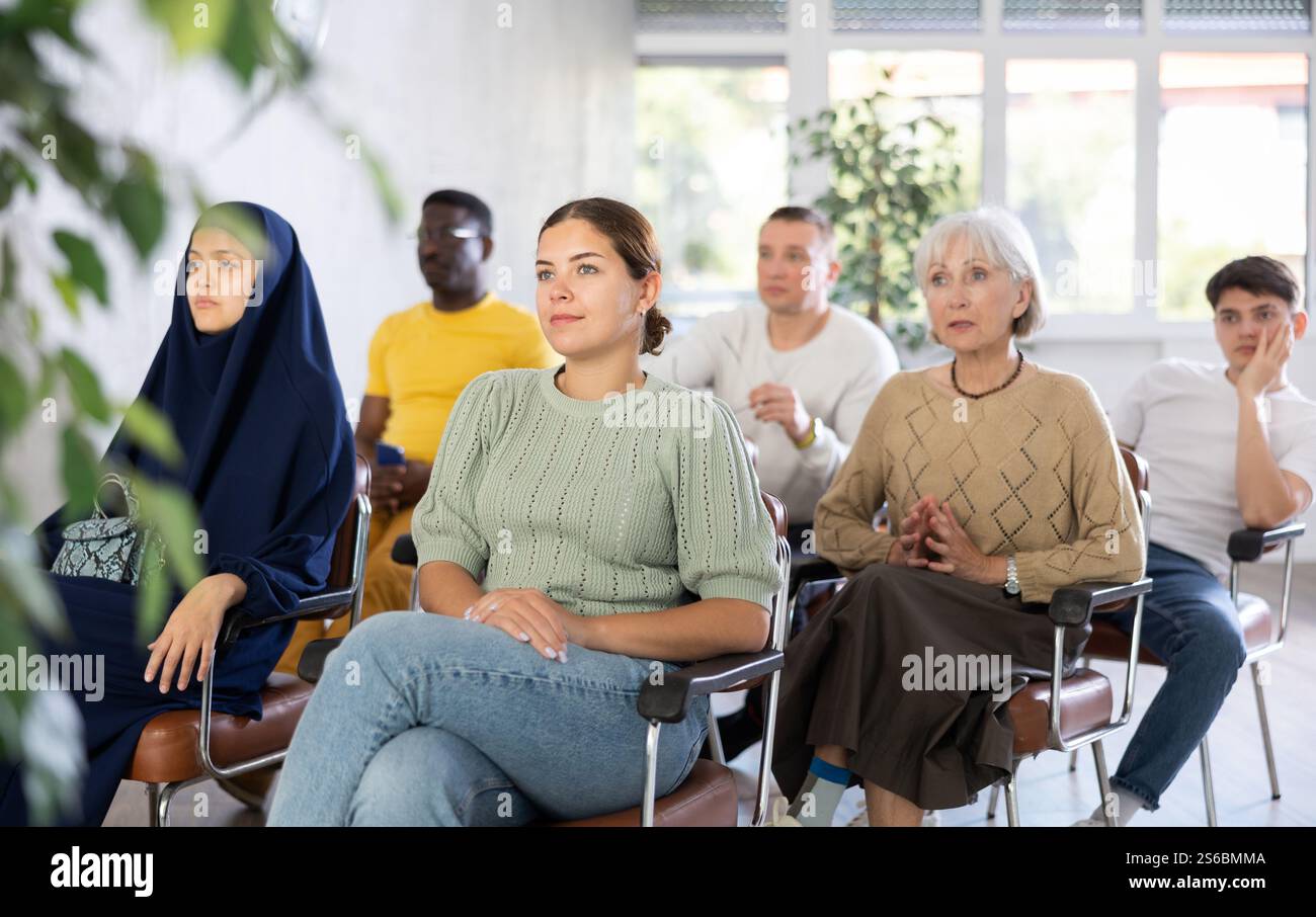 Positive multinational students listening to lecture in classroom Stock ...