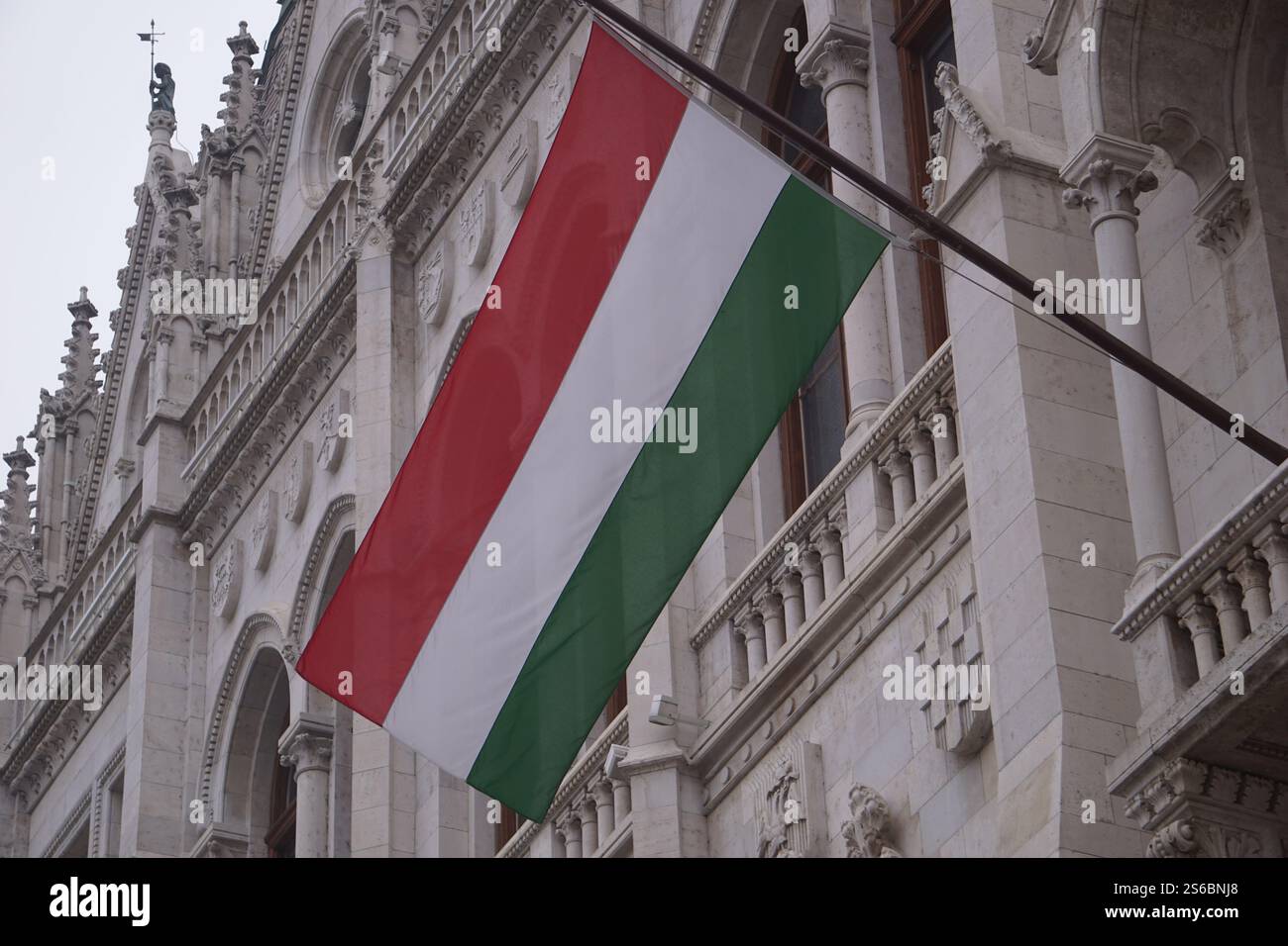 The Hungarian flag is flying in the wind at the historic Neo-Gothic facade of the Hungarian ...