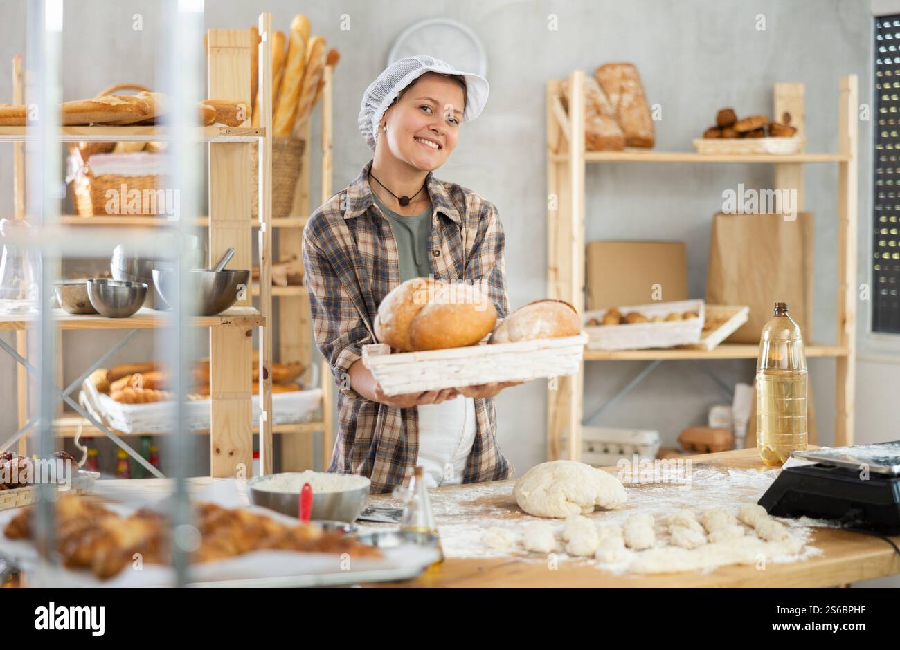 Bakery woman employee holds ready made bread of bread Stock Photo - Alamy