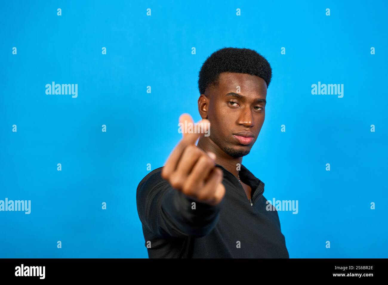 Stylish young man making korean finger heart sign expressing love and ...
