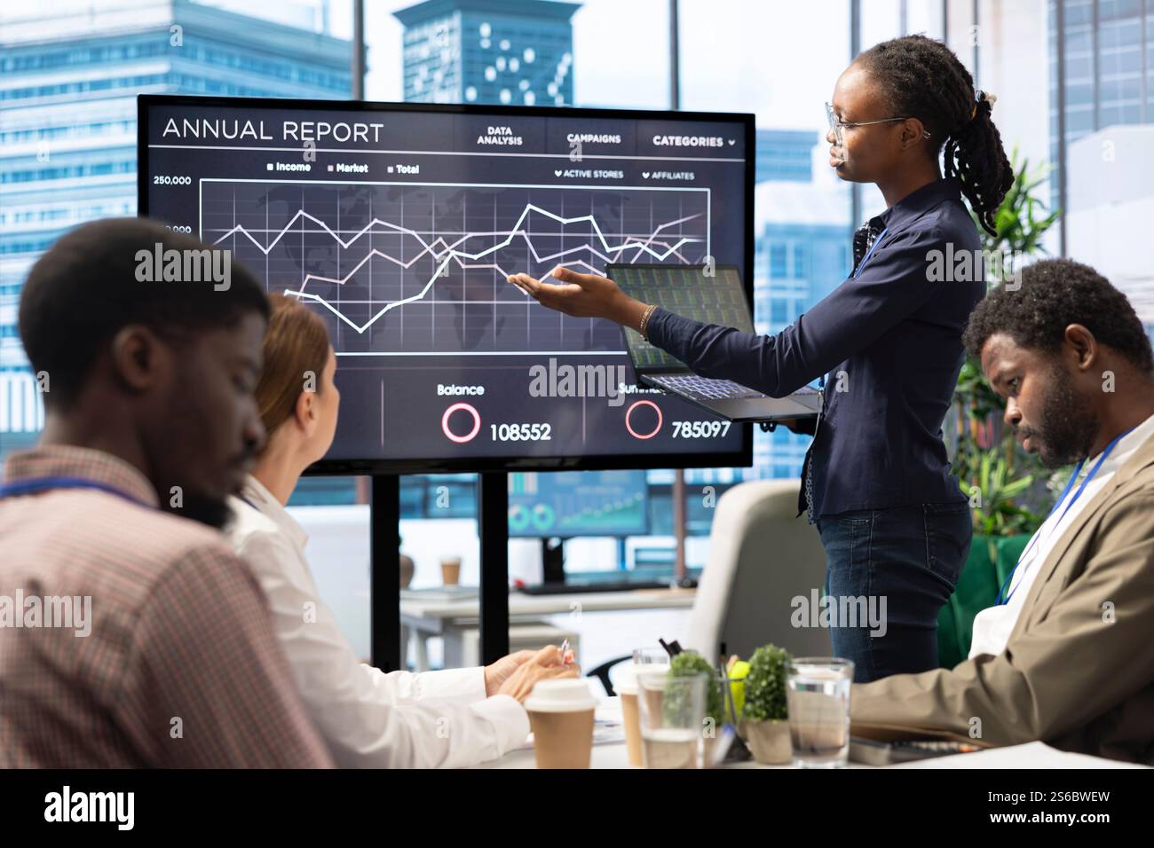 Diverse management team evaluates budget reports on interactive board ...