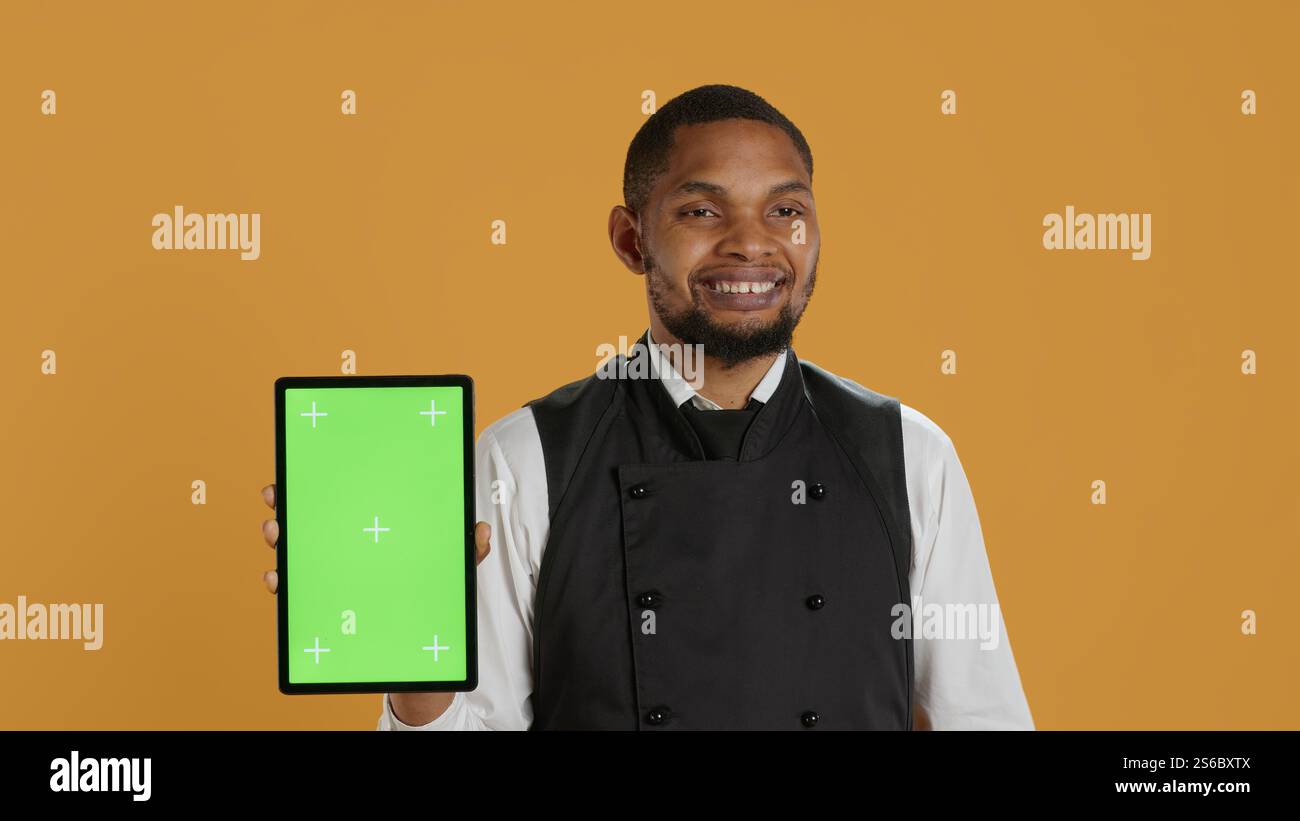 Professional waiter with apron presenting tablet with isolated mockup ...