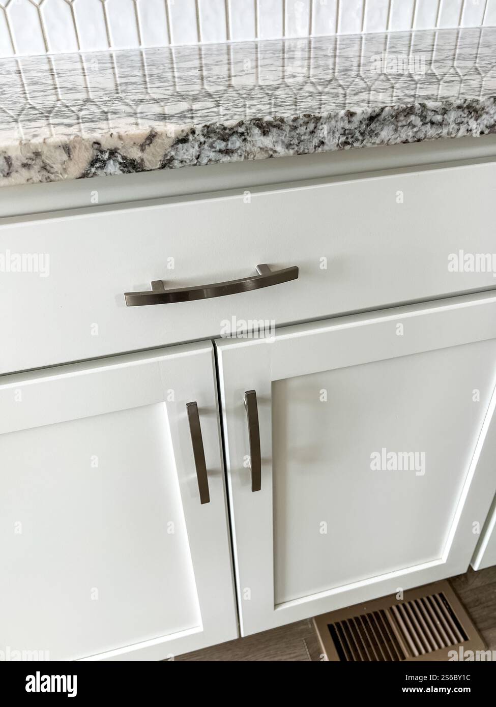White Kitchen Cabinet with Granite Countertop and Modern Hardware Stock ...