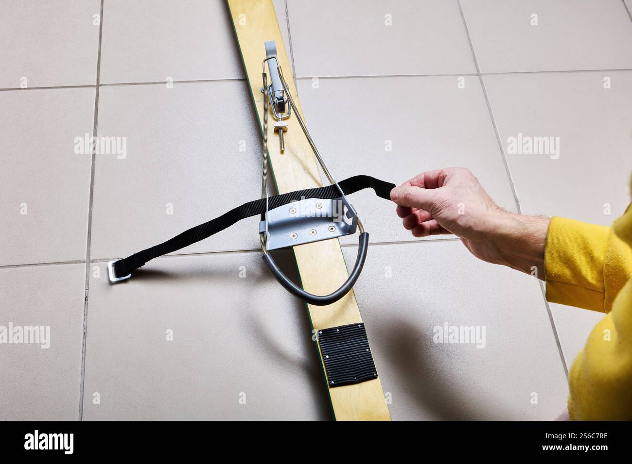 Adding strap to bracket of universal cable ski bindings during ...